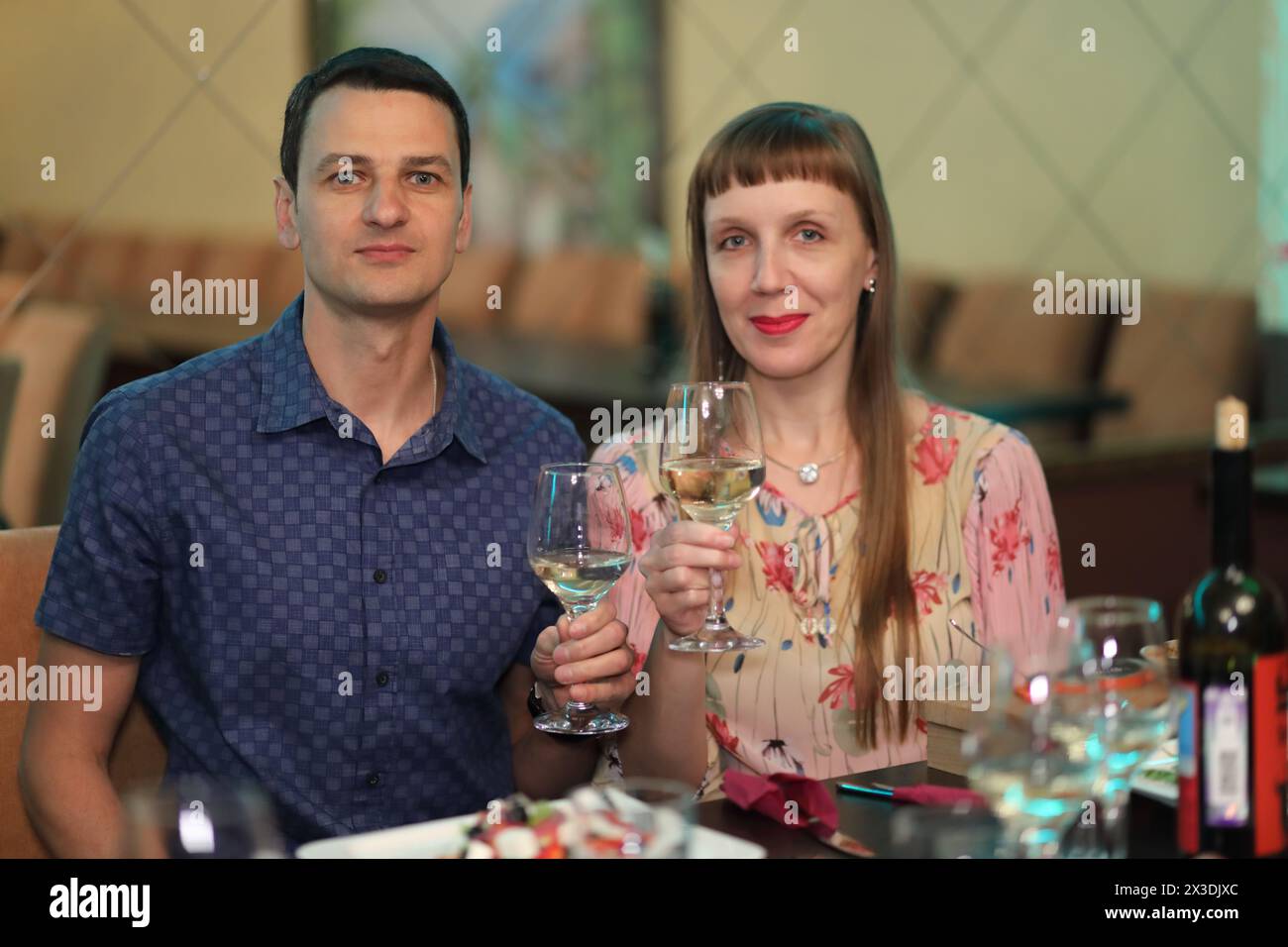 husband and wife (with model releases) with raised wine glasses on ...