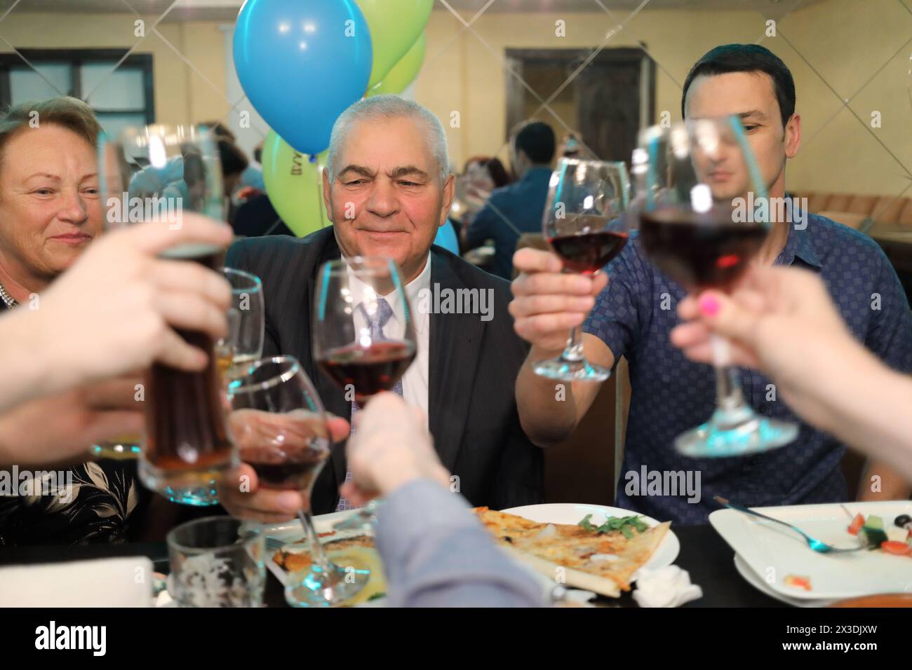 guests at table on anniversary, hands holding glasses and toasting ...