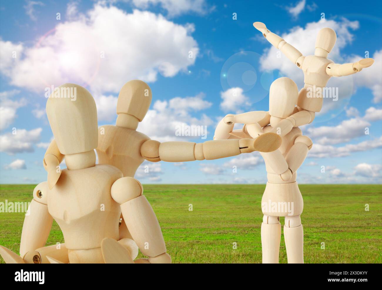 Collage with two wooden figures of child sitting on neck of his parents ...