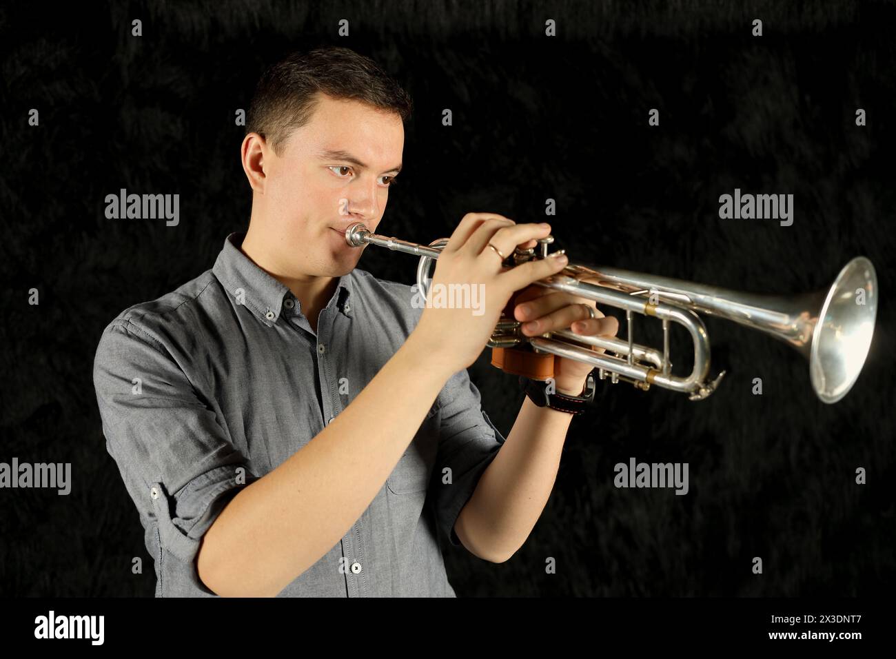 Portrait of trumpet player in a gray shirt in a black room Stock Photo ...