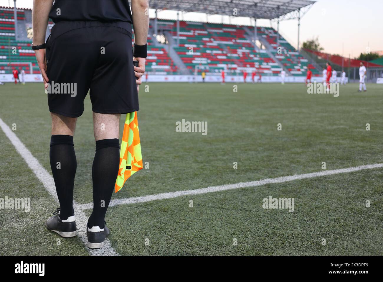 A judge with a flag on the football field before the teams of players ...
