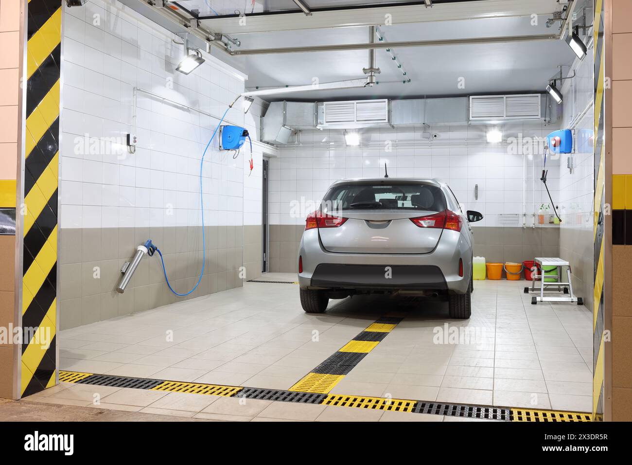 Silver car in a car wash room, rear view Stock Photo - Alamy