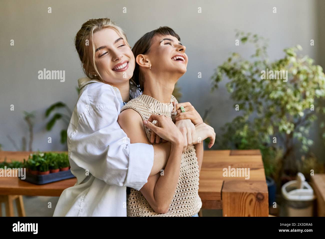 Two women lovingly embrace in an art studio Stock Photo - Alamy