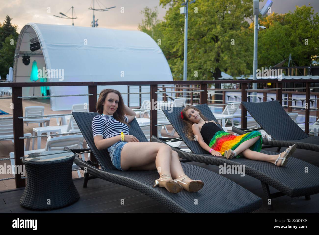 Mother with her daughter is laying on the deckchairs Stock Photo - Alamy