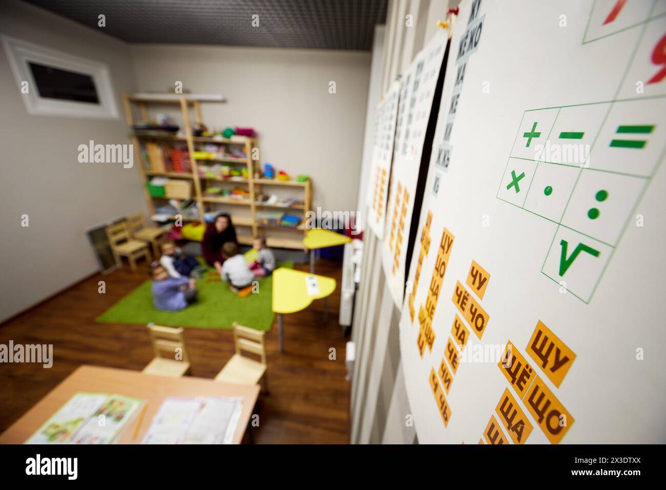 Children and nursery teacher in children club classroom, focus on ...