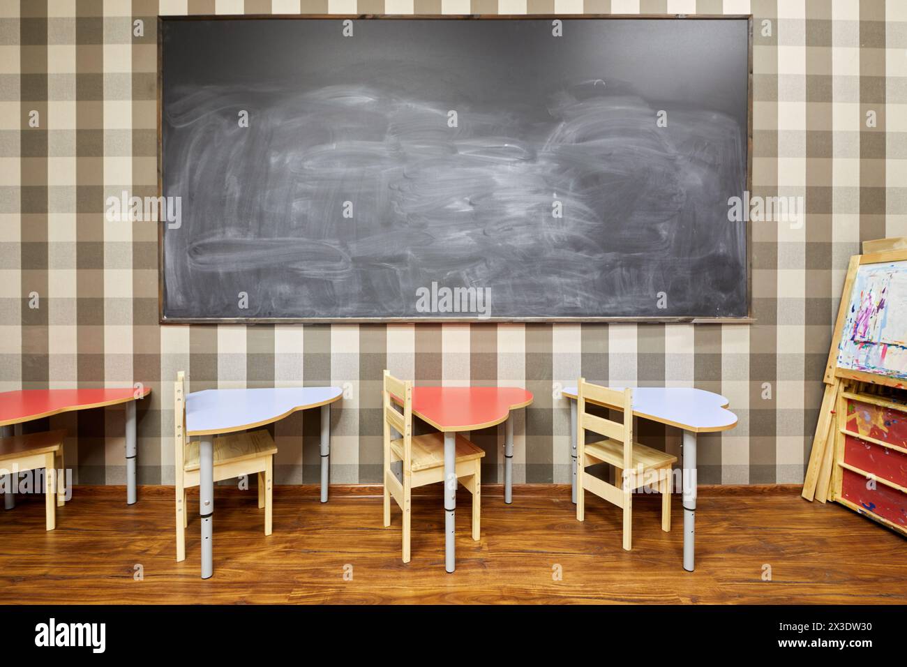 Blackboard on wall and desks with chairs in classroom at chidren club ...