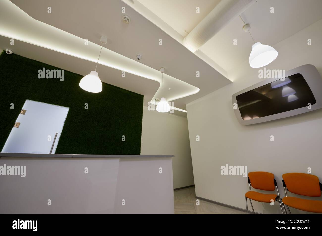 Interior of modern reception hall with front desk, chairs and monitor ...