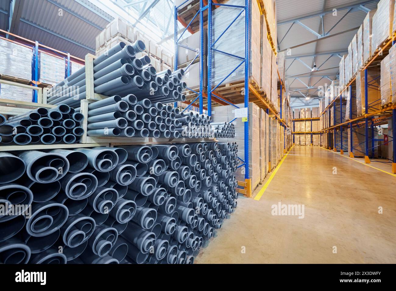 Warehouse with plastic pipes and cardboard boxes on shelves at factory ...