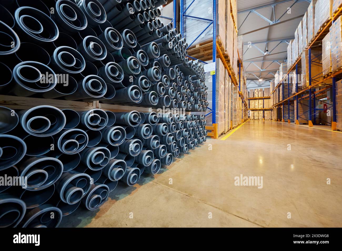 Warehouse with cardboard boxes on shelves and plastic pipes at factory ...