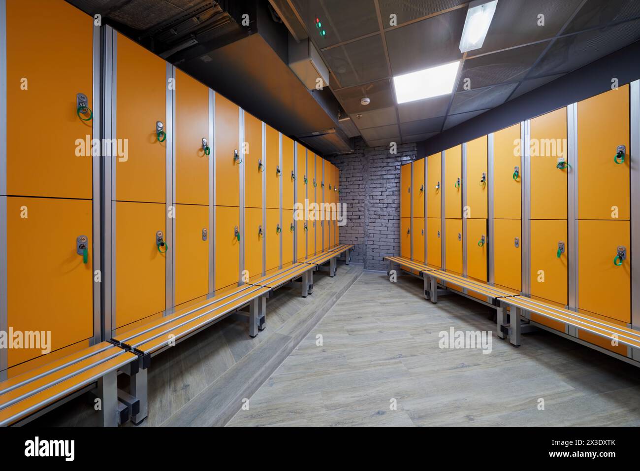 Room with rows of orange lockers at fitness center Stock Photo - Alamy