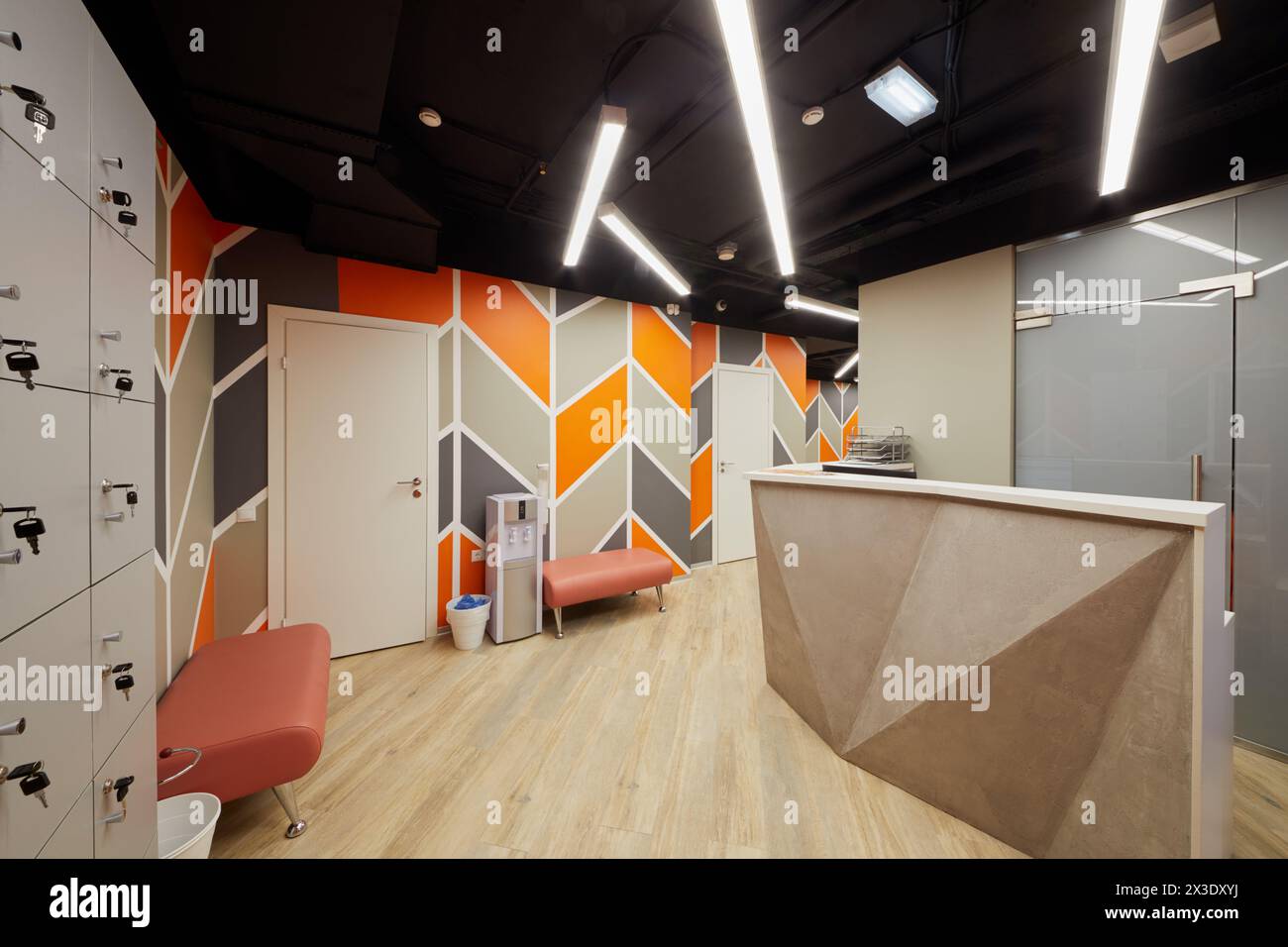 Reception area with desk, benches, lockers, water dispenser Stock Photo ...