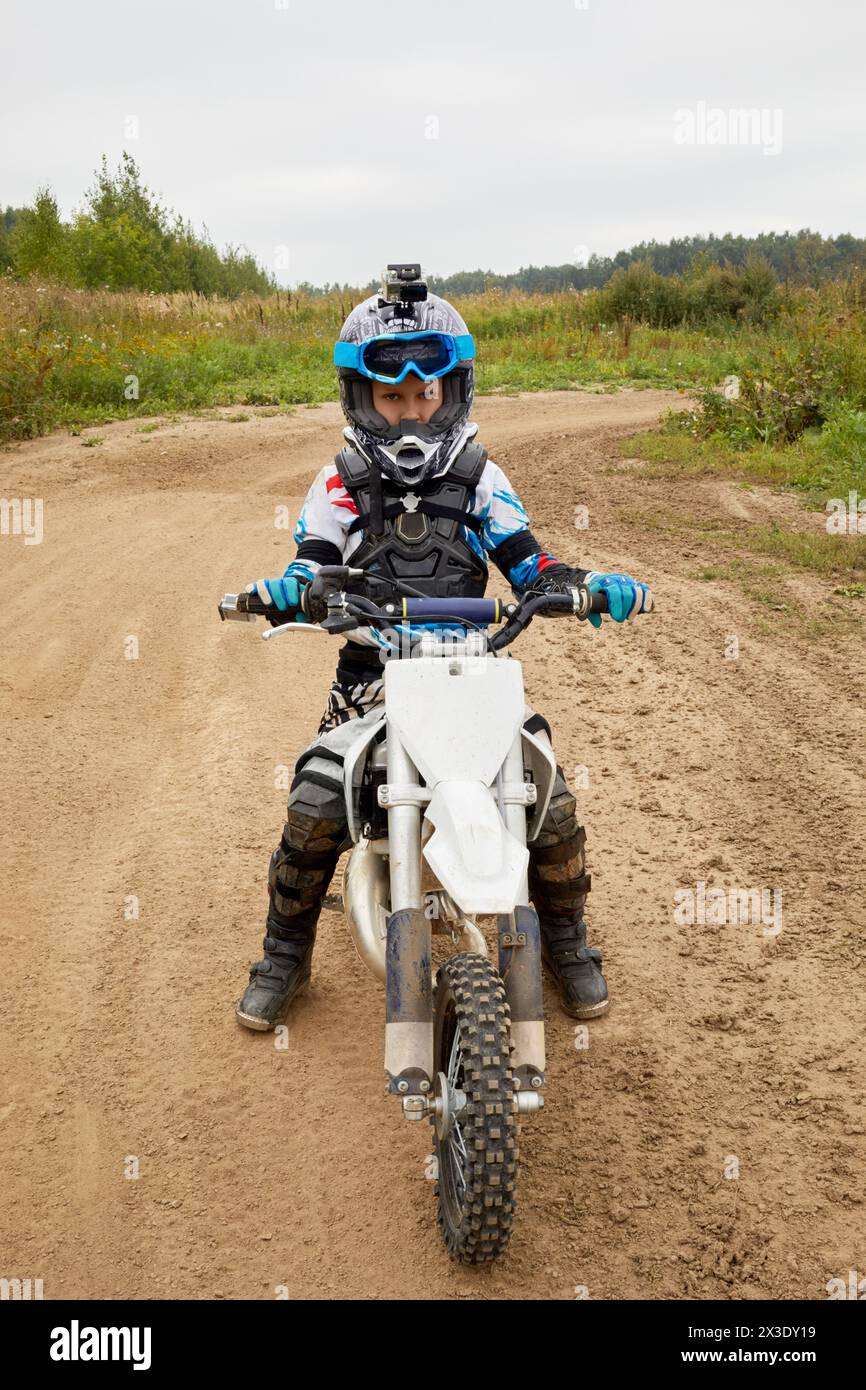 Boy dressed and equipped sits on racing motorcycle on track road Stock ...