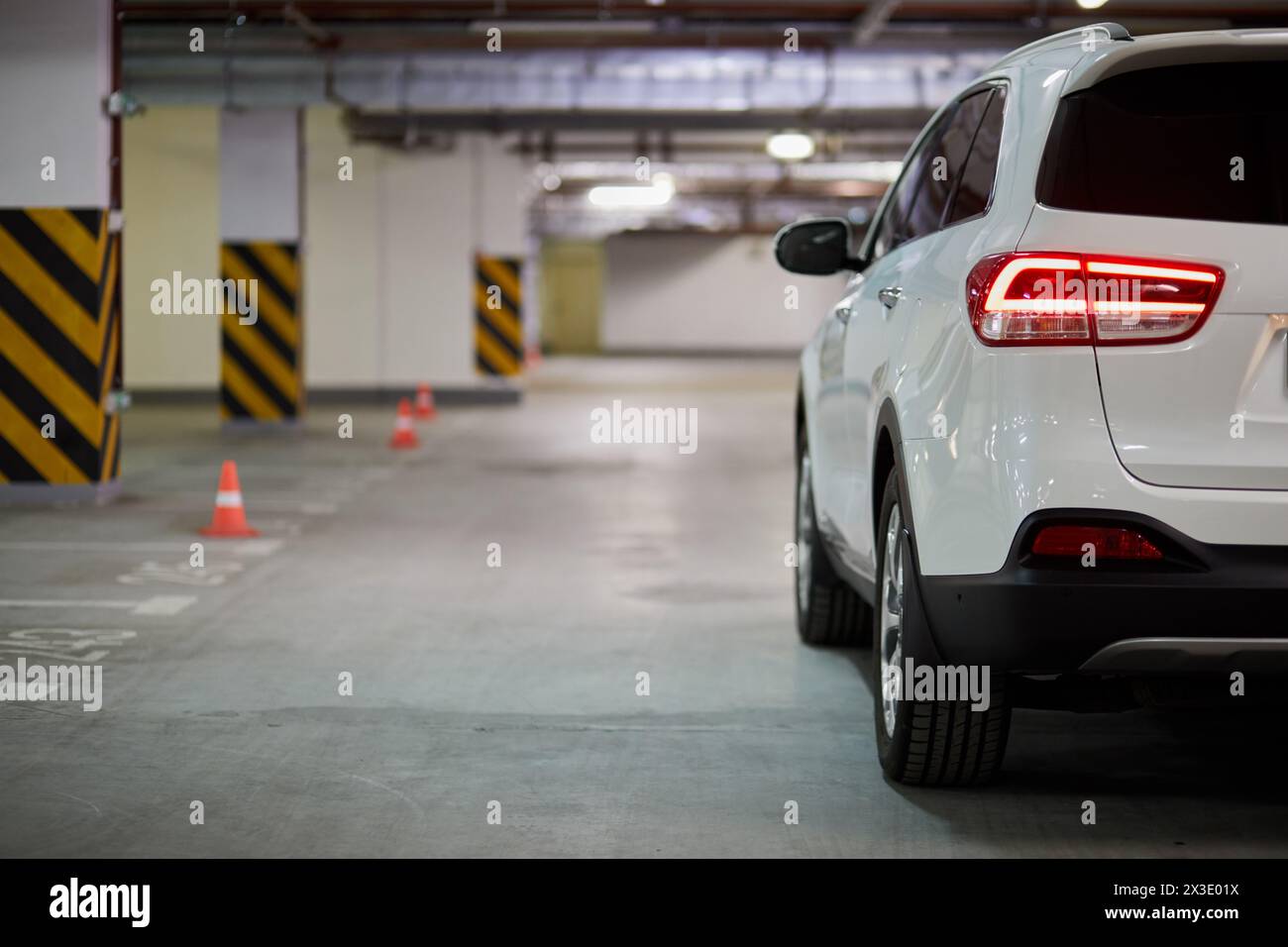 Driver side of white modern car at underground parking, side rear view ...