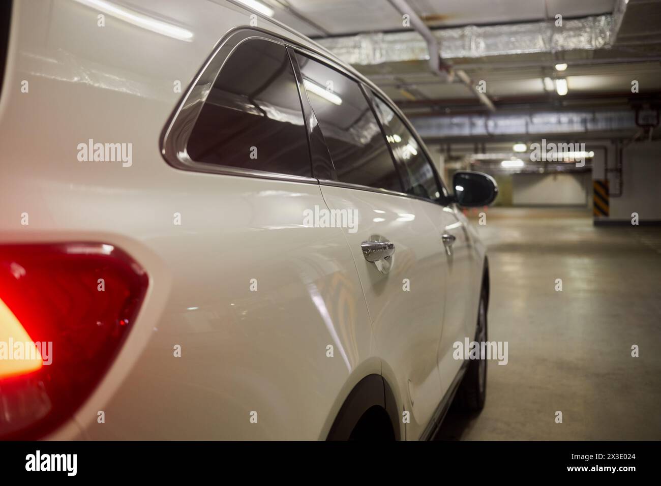 Right side of white modern car at underground parking, side rear view ...