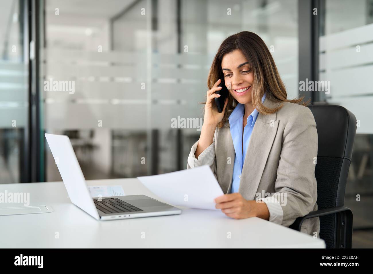 Happy professional woman executive making call talking on phone at work ...