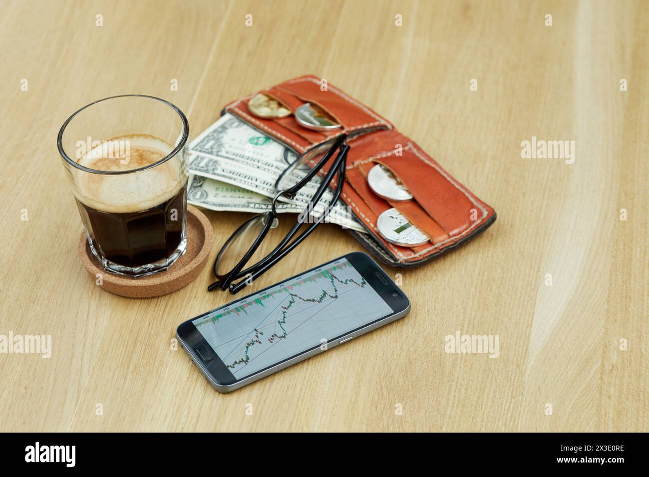 Glass of coffee, smartphone with financial charts, glasses and red ...