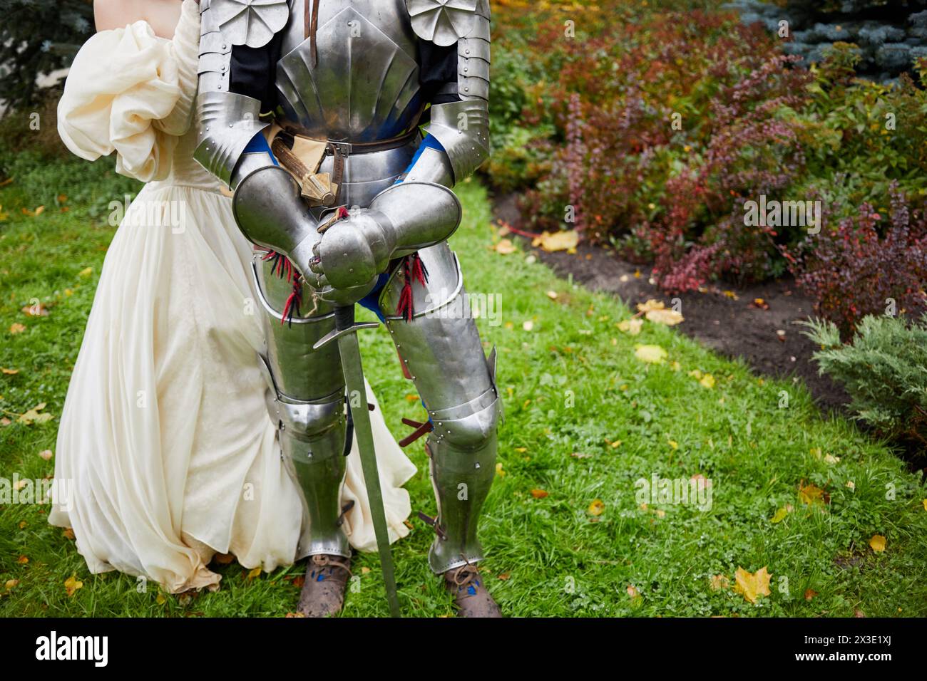 Man dressed in suit of knight armor with sword and girl in gorgeous ...