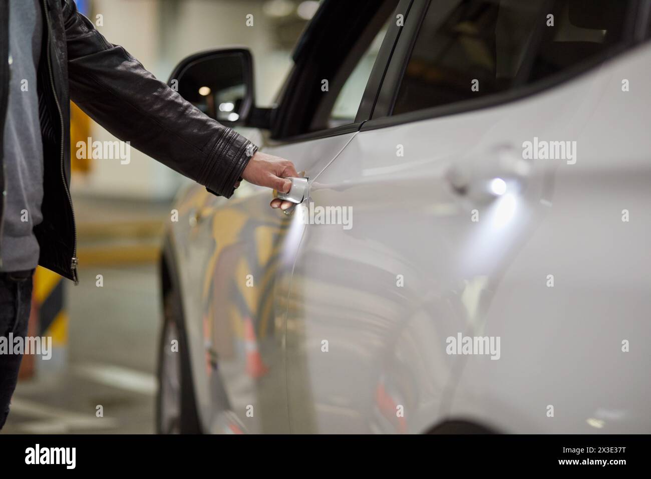 Male hand opens door of white car at underground parking Stock Photo ...