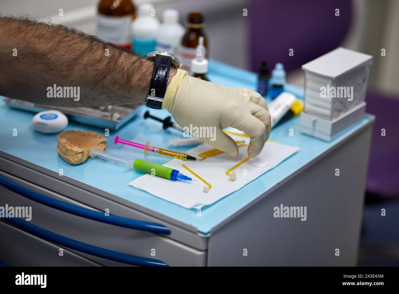 Dentist hand in glove above medical table with implants on holders and ...