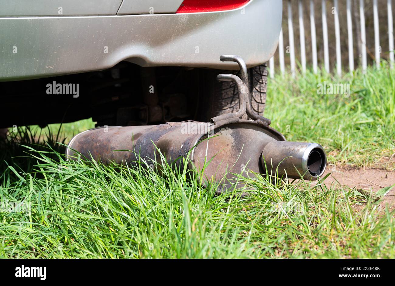 Broken exhaust and muffler of a car, rusted silencer fallen down on the ...