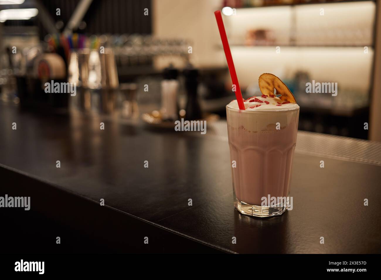 Glass of milkshake with caramels and fruit chips on counter Stock Photo ...