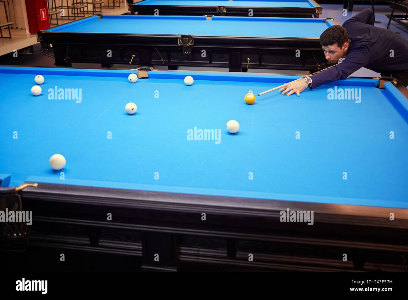 Man in dark blue shirt plays russian pyramid in billiard club Stock ...