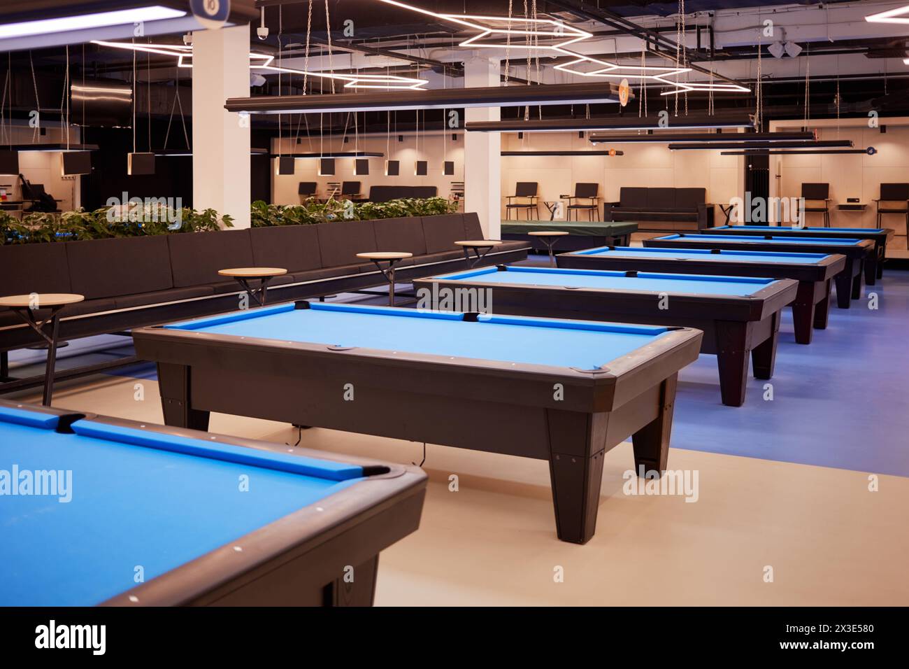 Interior of billiard club with row of billiard tables, chairs, sofas ...