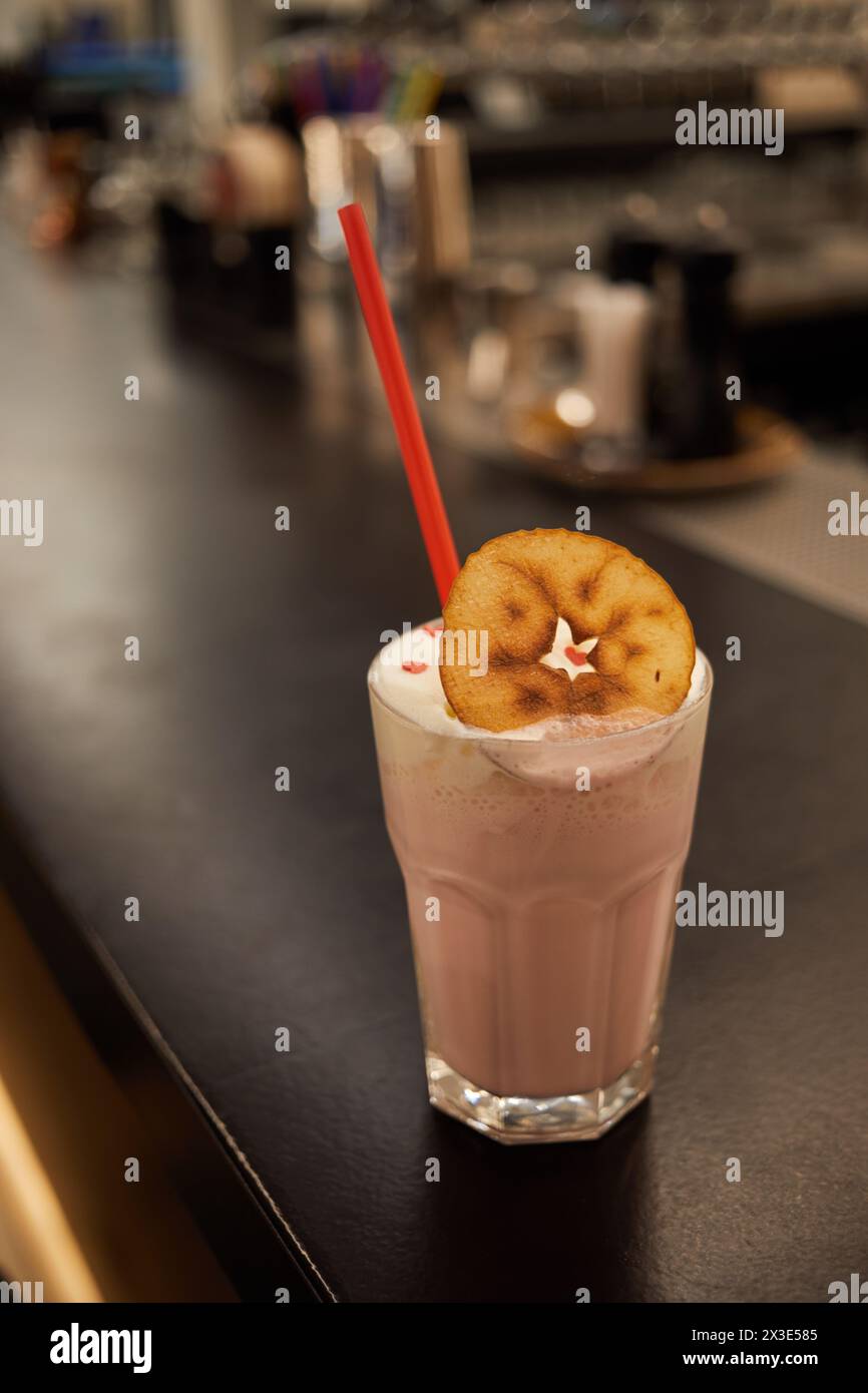 Glass of milkshake with fruit chips on counter Stock Photo - Alamy