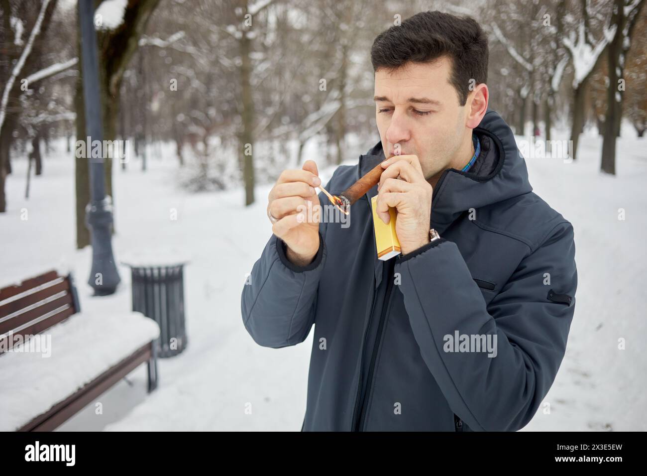 Man puffs at cigar in winter snowy park Stock Photo - Alamy