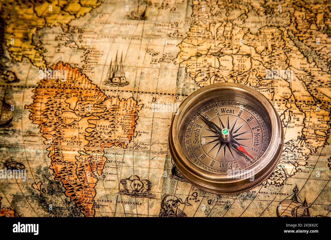 Vintage still life. Vintage compass lies on an ancient world map of ...