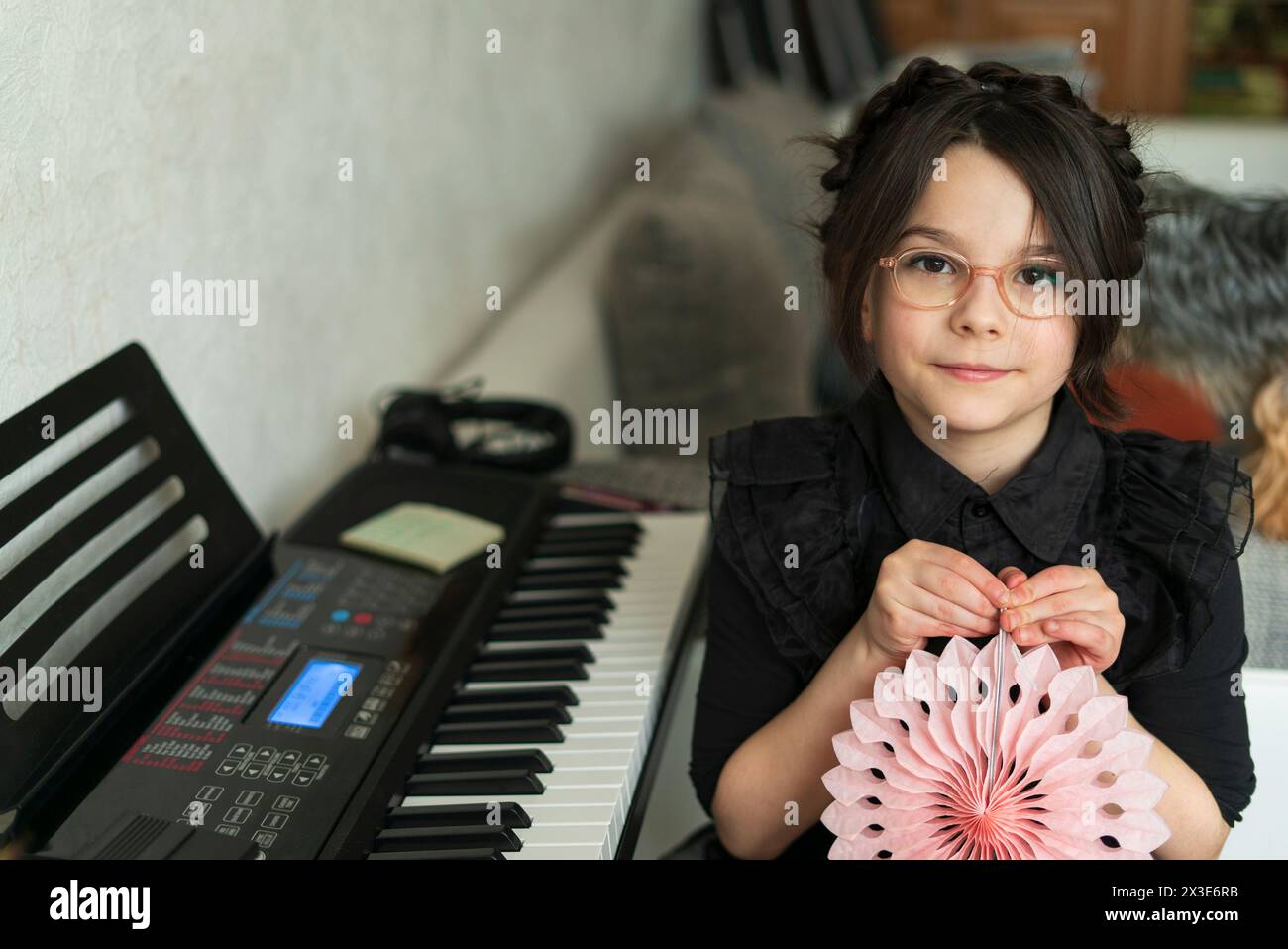 Little girl playing the piano at home. Little girl with glasses and a ...