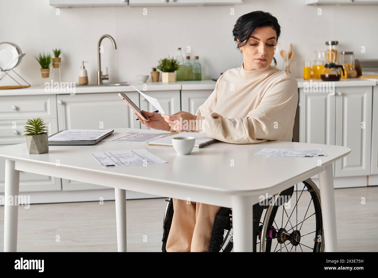 A disabled woman in a wheelchair works remotely using a tablet at her ...