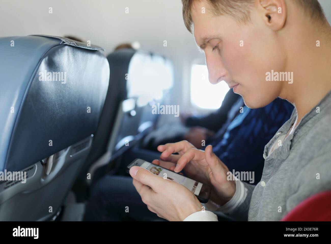 Man with cell phone is in flying aircraft, shallow dof, profile Stock ...