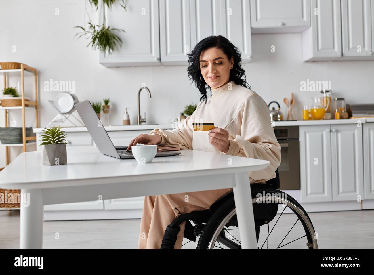 A disabled woman in a wheelchair works remotely on her laptop from her ...