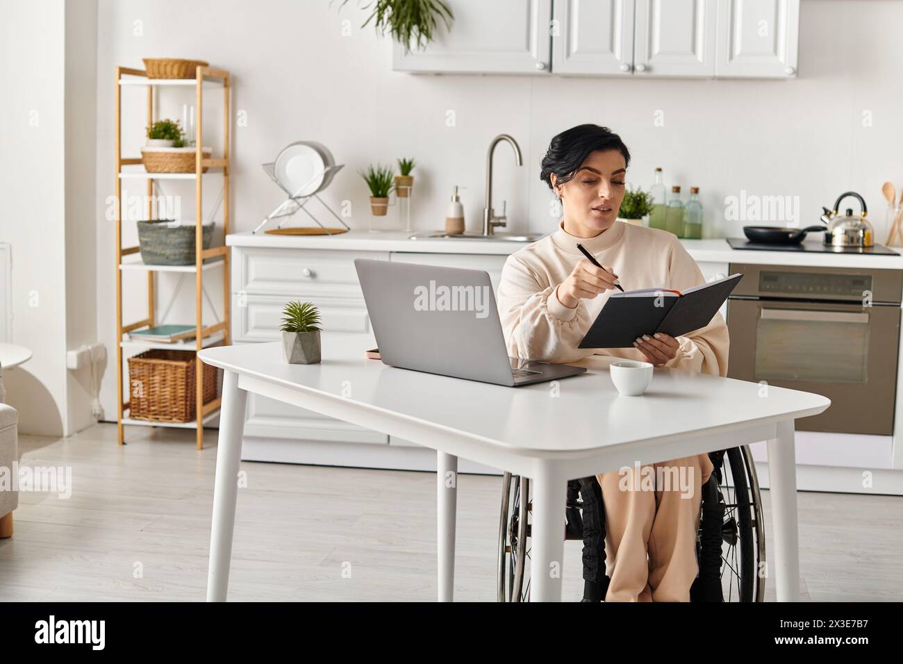 A disabled woman in a wheelchair, working remotely, sits at a table ...