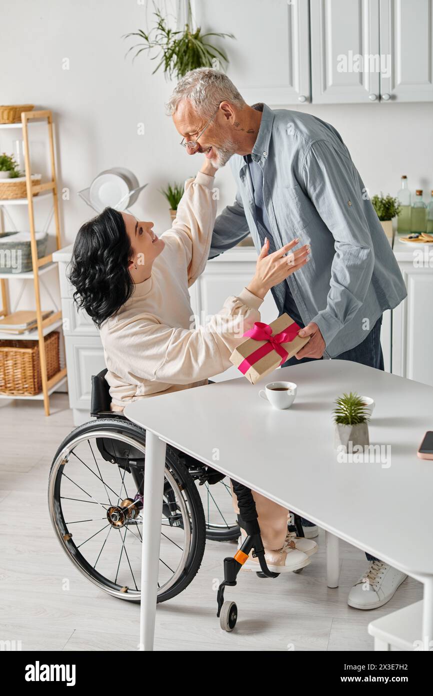 A disabled woman in a wheelchair touching her husbands hand lovingly in ...