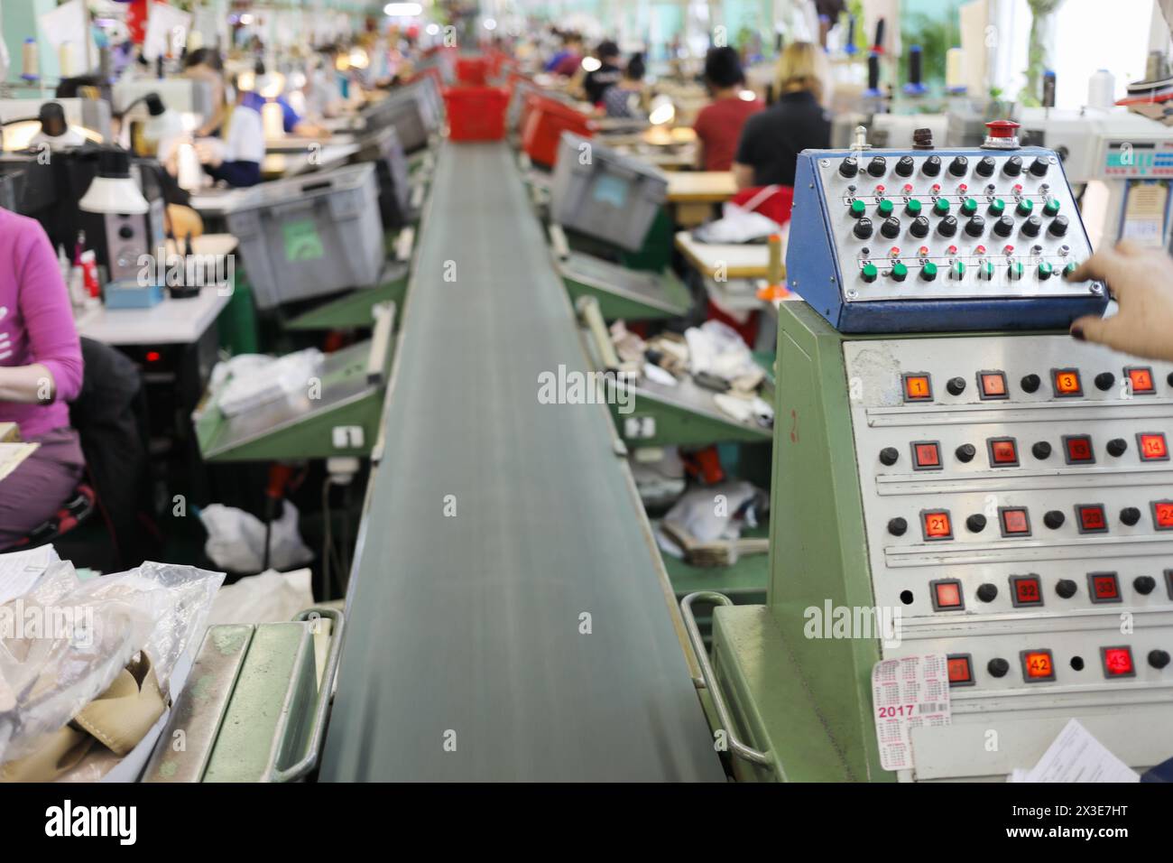People near assembly line in workshop of shoes factory, focus on ...