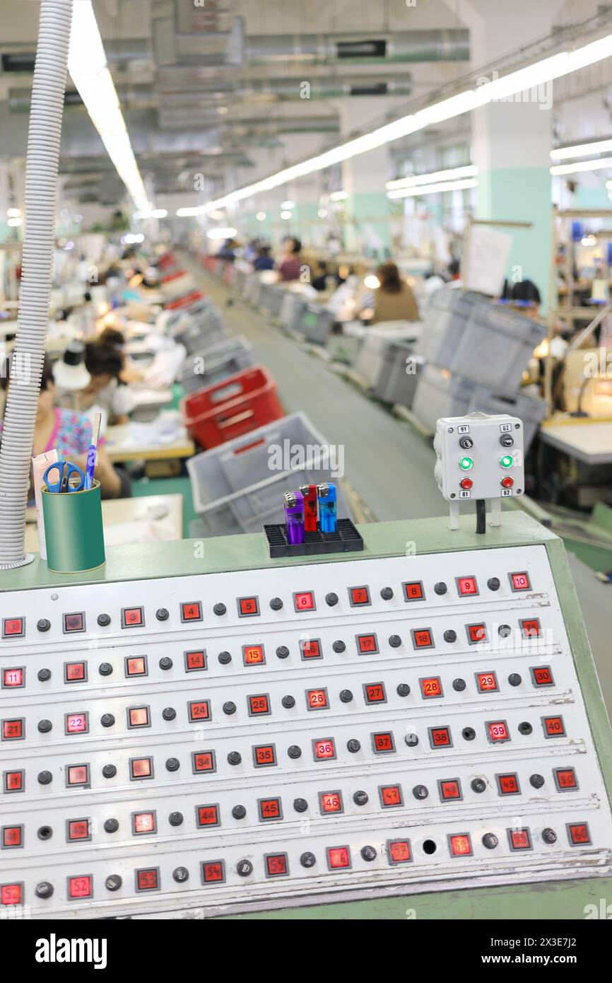 Working people near assembly line in workshop of shoes factory, focus ...