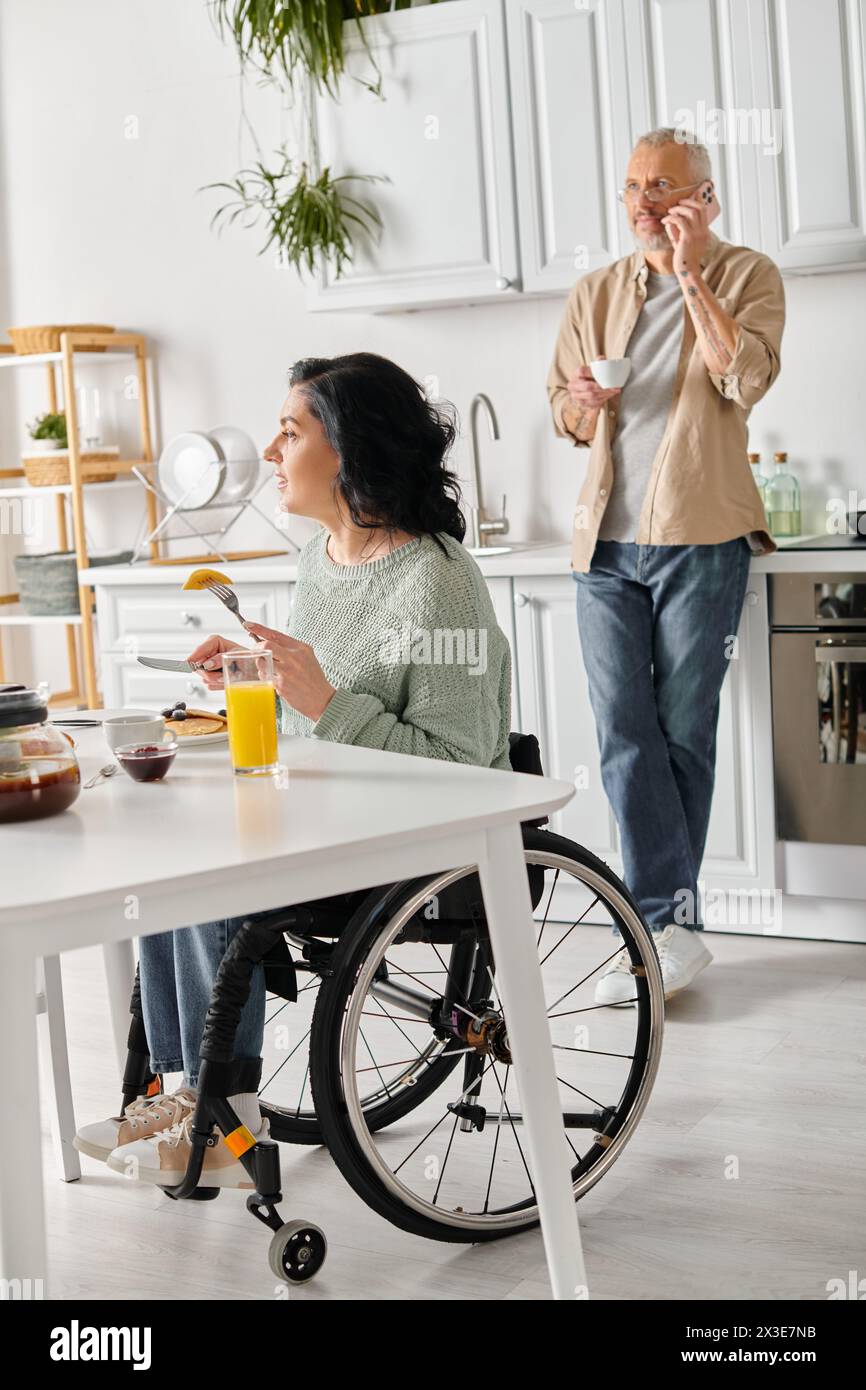 A husband and his disabled wife, in a wheelchair, stand side by side at ...