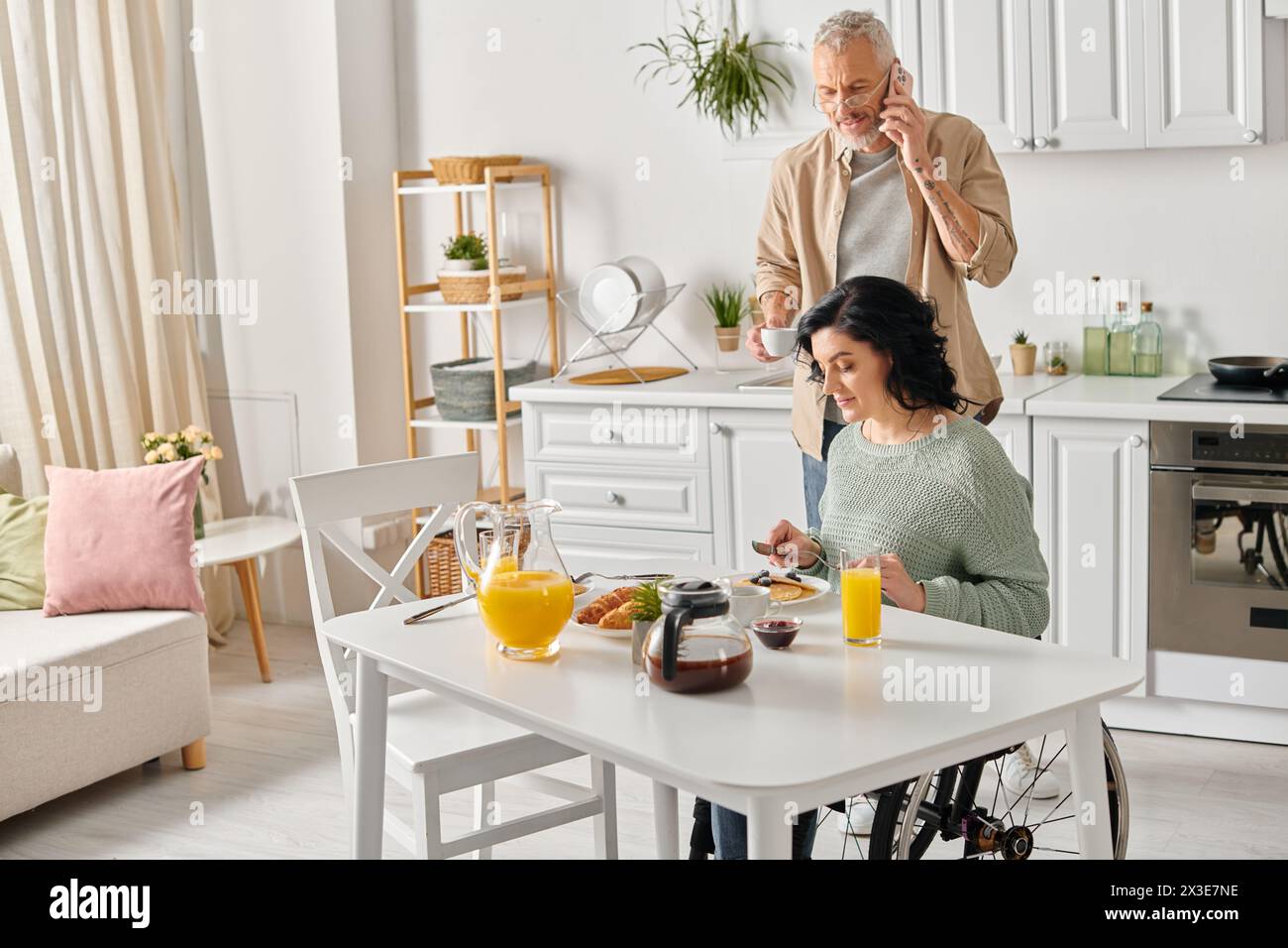A husband and disabled wife in a wheelchair, stand side by side at a ...