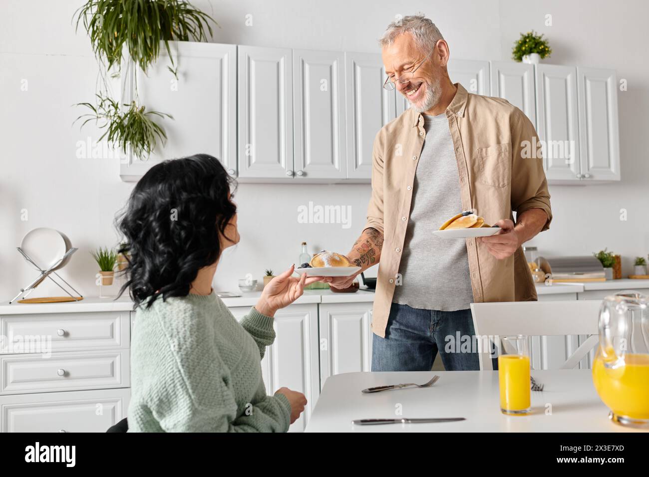 A disabled woman in a wheelchair and her husband sit at a table in a ...