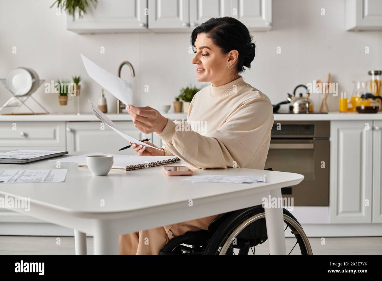 A disabled woman in a wheelchair sits in her kitchen, holding a piece ...