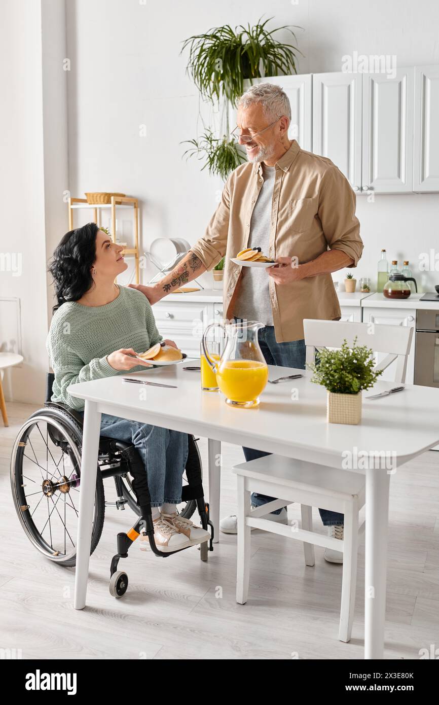 A man in a wheelchair lovingly serves food to his disabled wife in ...