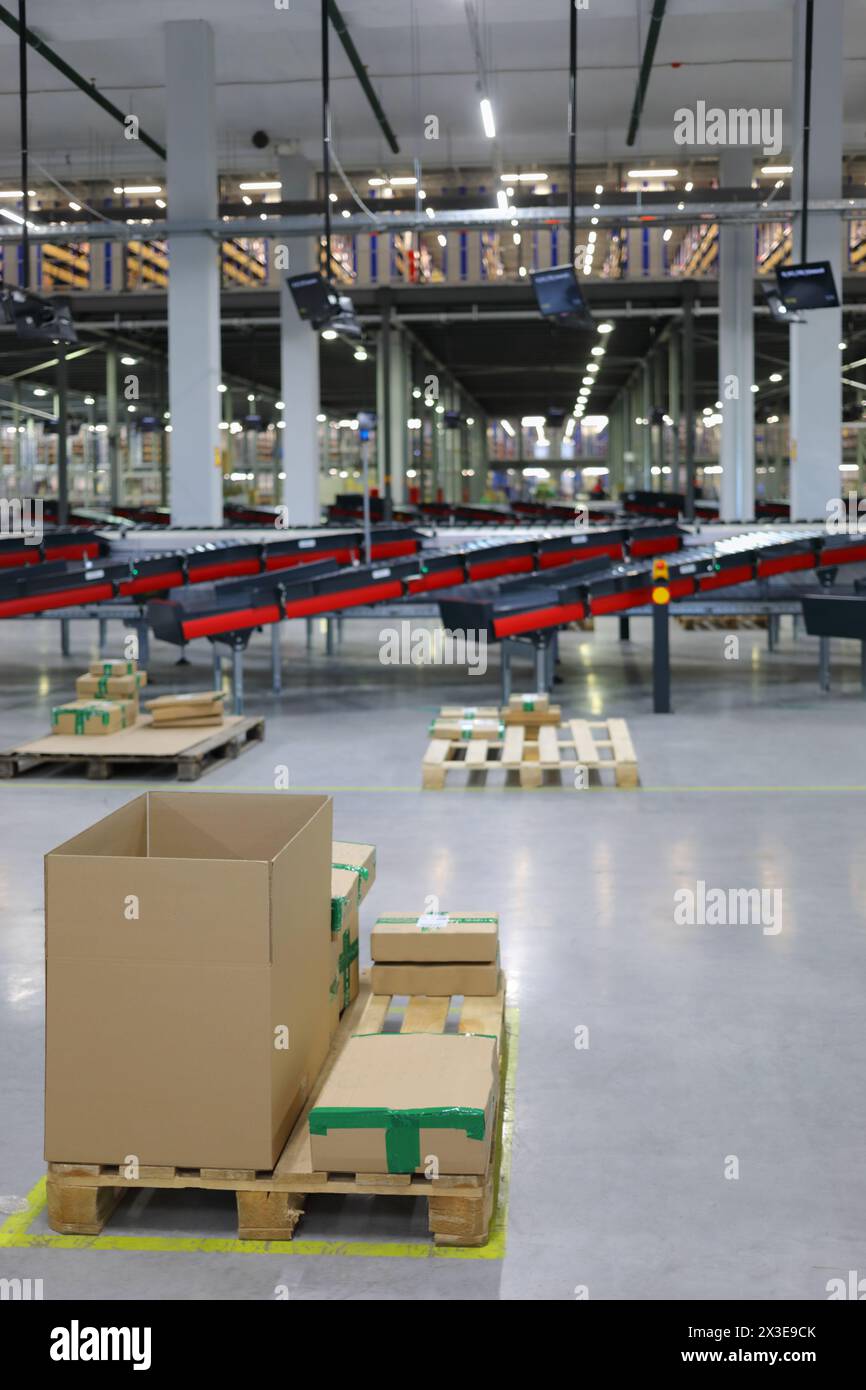 Modern warehouse with cardboard boxes, conveyors for sorting of goods ...