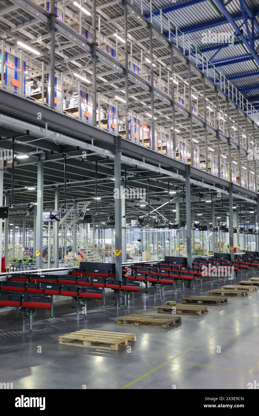 Empty modern two-storey workshop with conveyors for sorting of goods ...