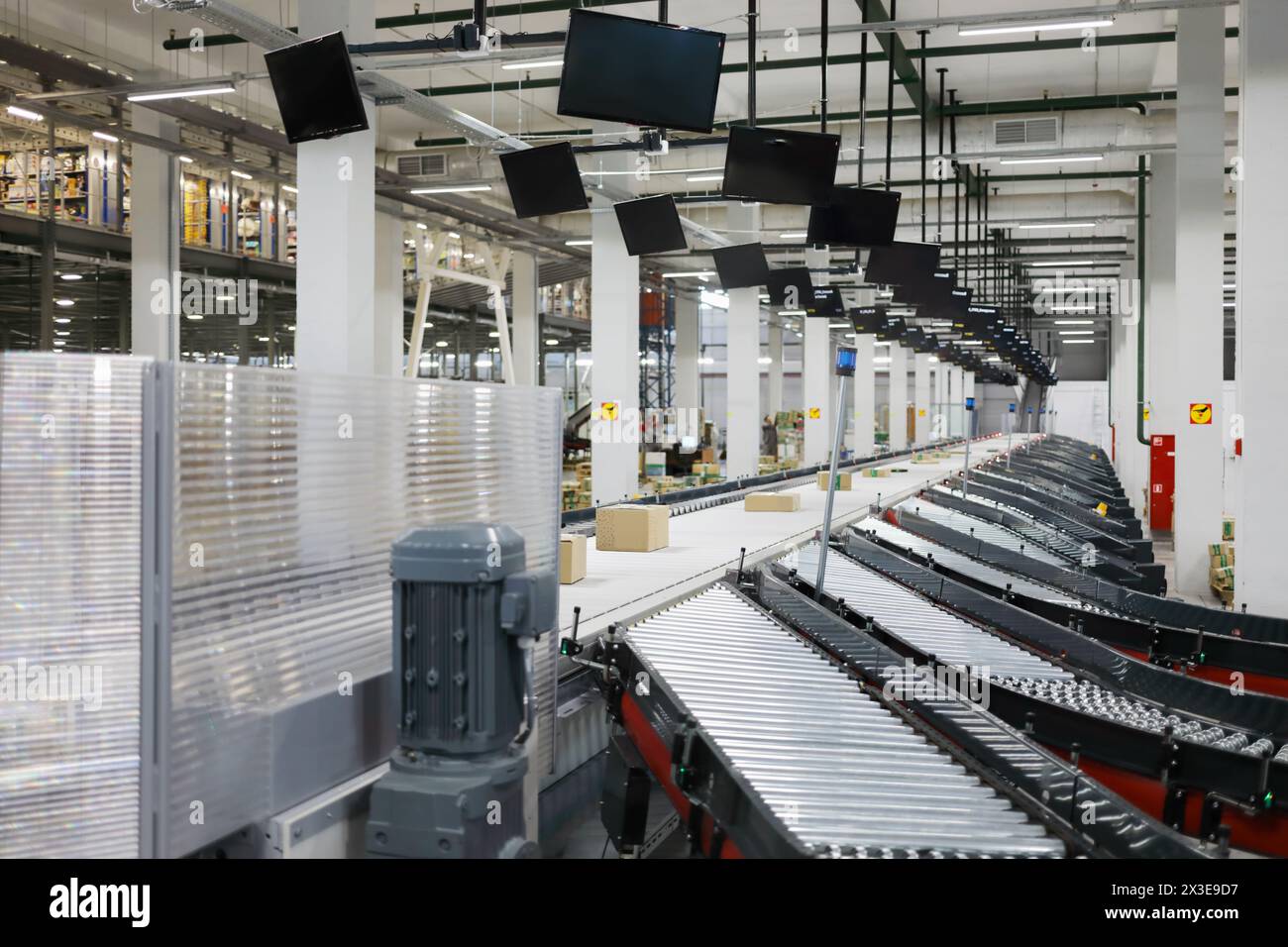Empty modern workshop with conveyor, many displays in large warehouse ...