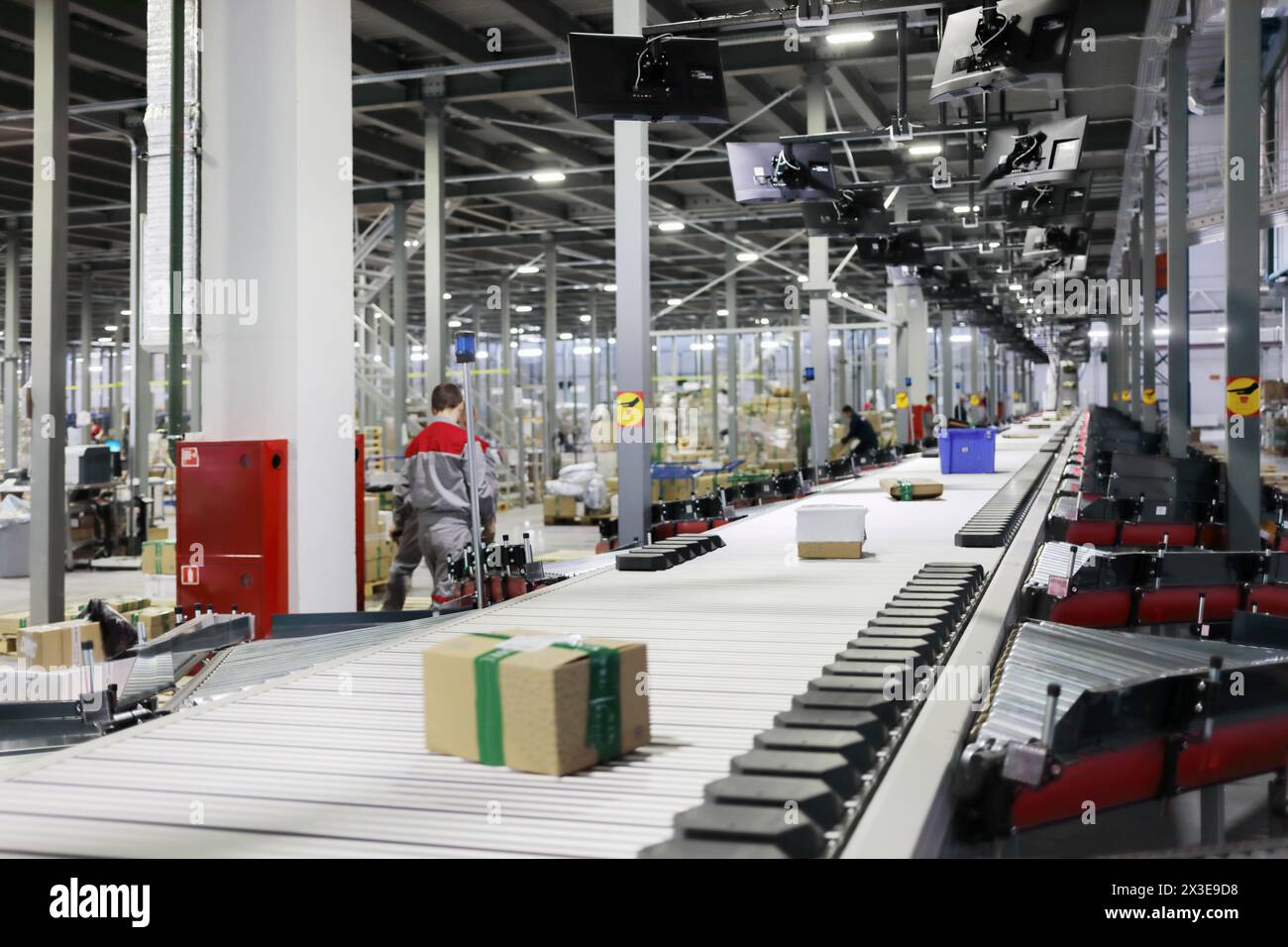People work in modern workshop with conveyor, many displays in ...