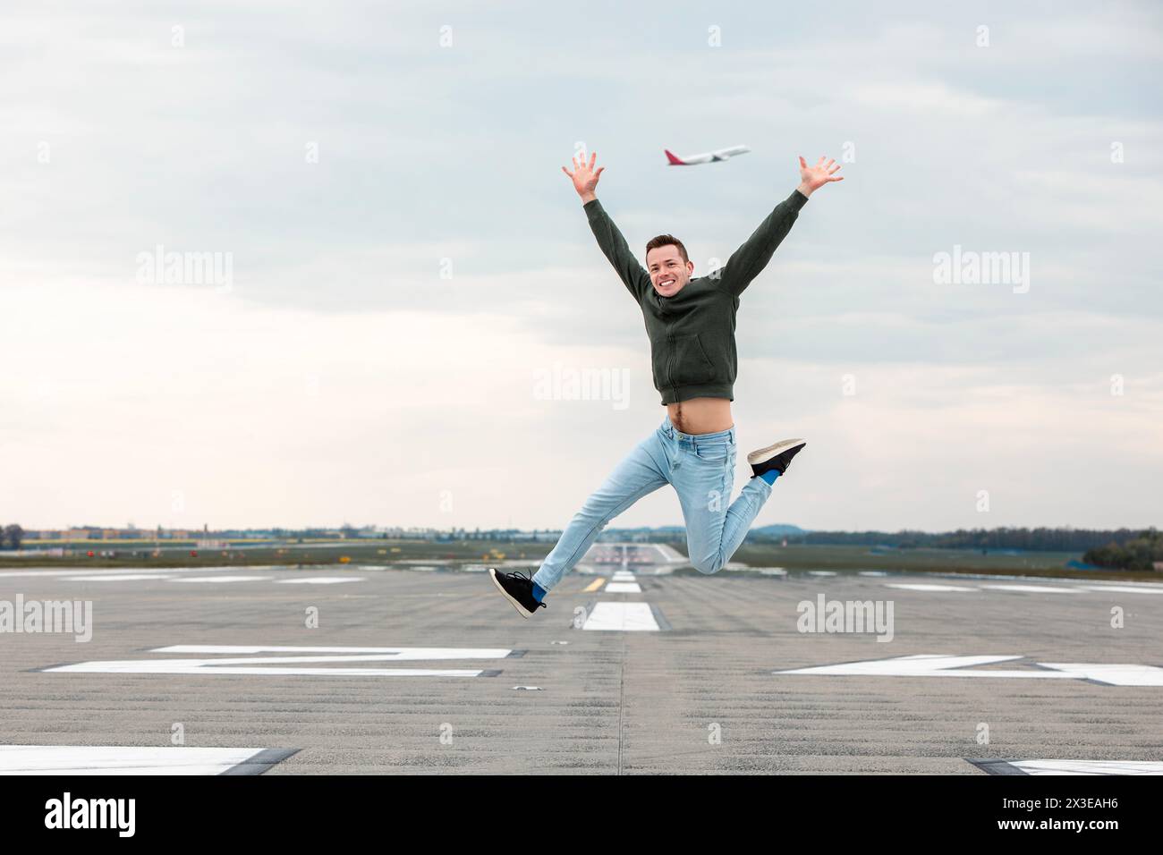 Concept of joyful and carefree travel. Happy man with arms up jumping ...