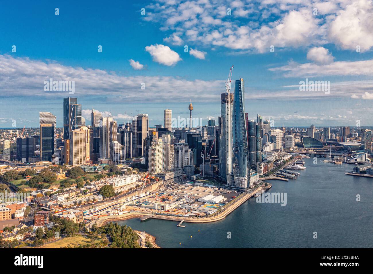 Aerial view modern skyscrapers and buildings near ocean and cloudy sky ...