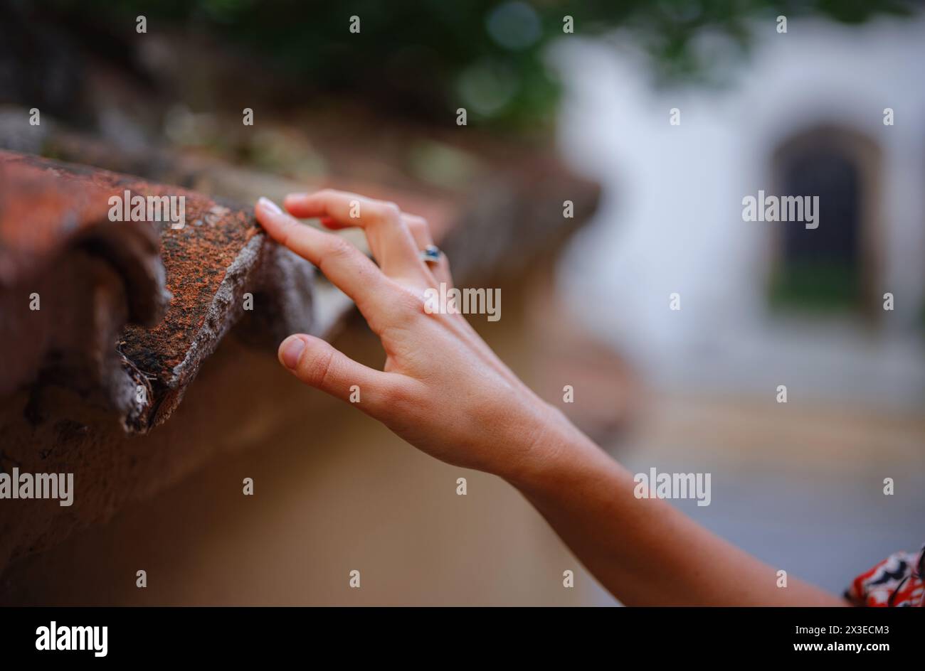 Female hand gently touches weathered tiles in old town of Kalechi ...